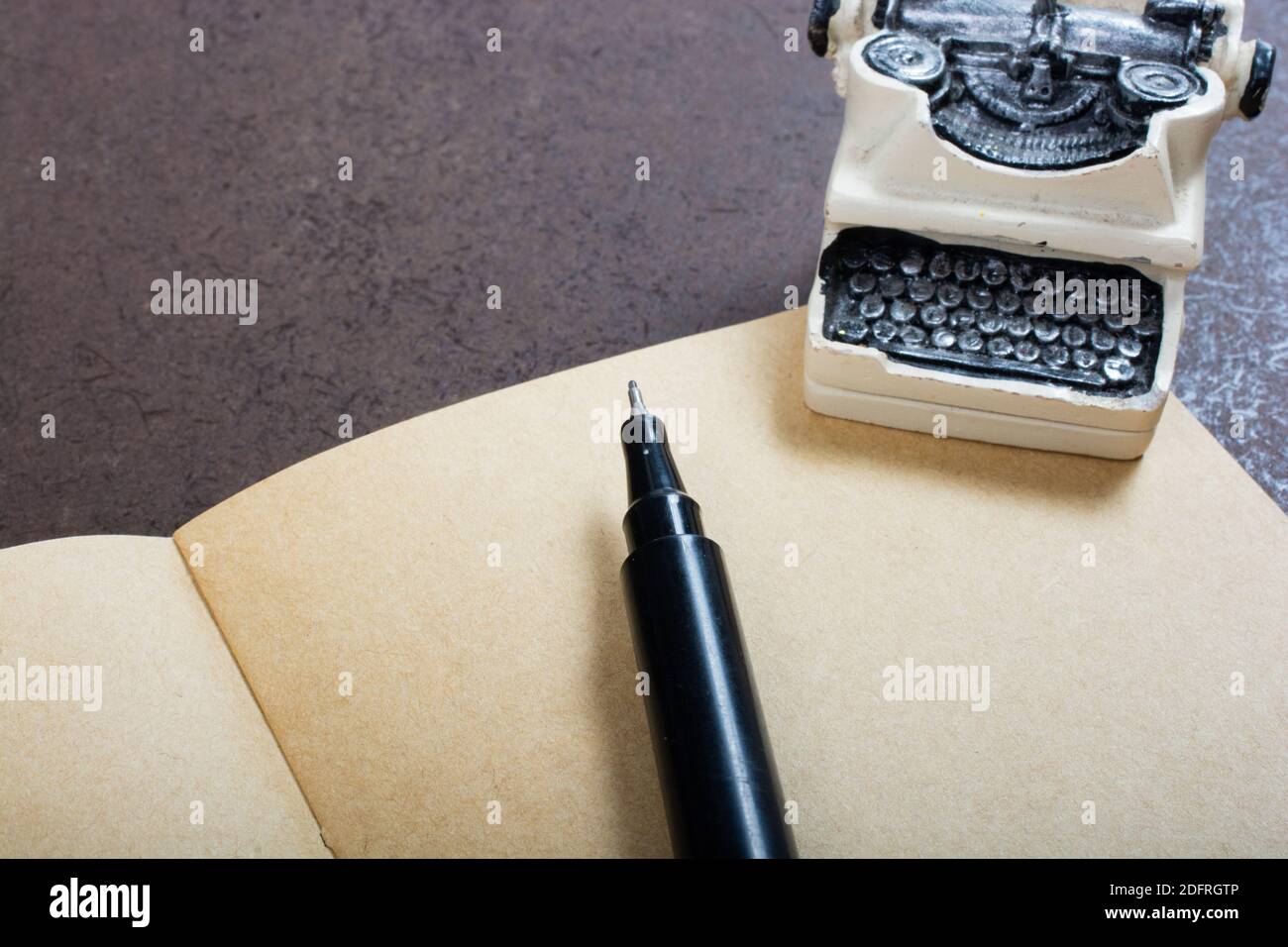 Pen and typewriter on notebook on brown color background in view Stock ...