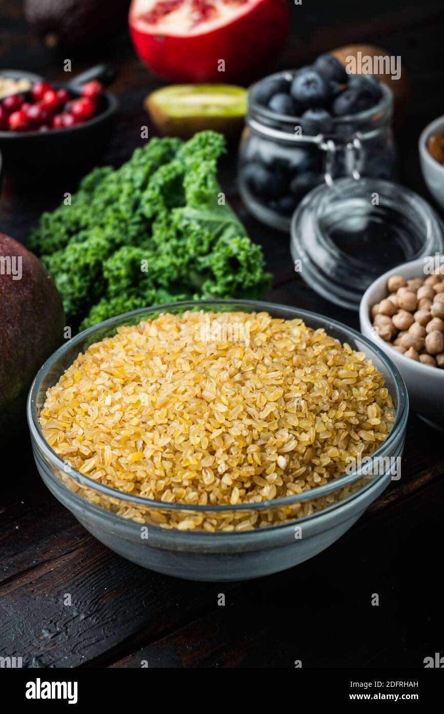 Bulgur grain in bowl on dark wooden background Stock Photo - Alamy