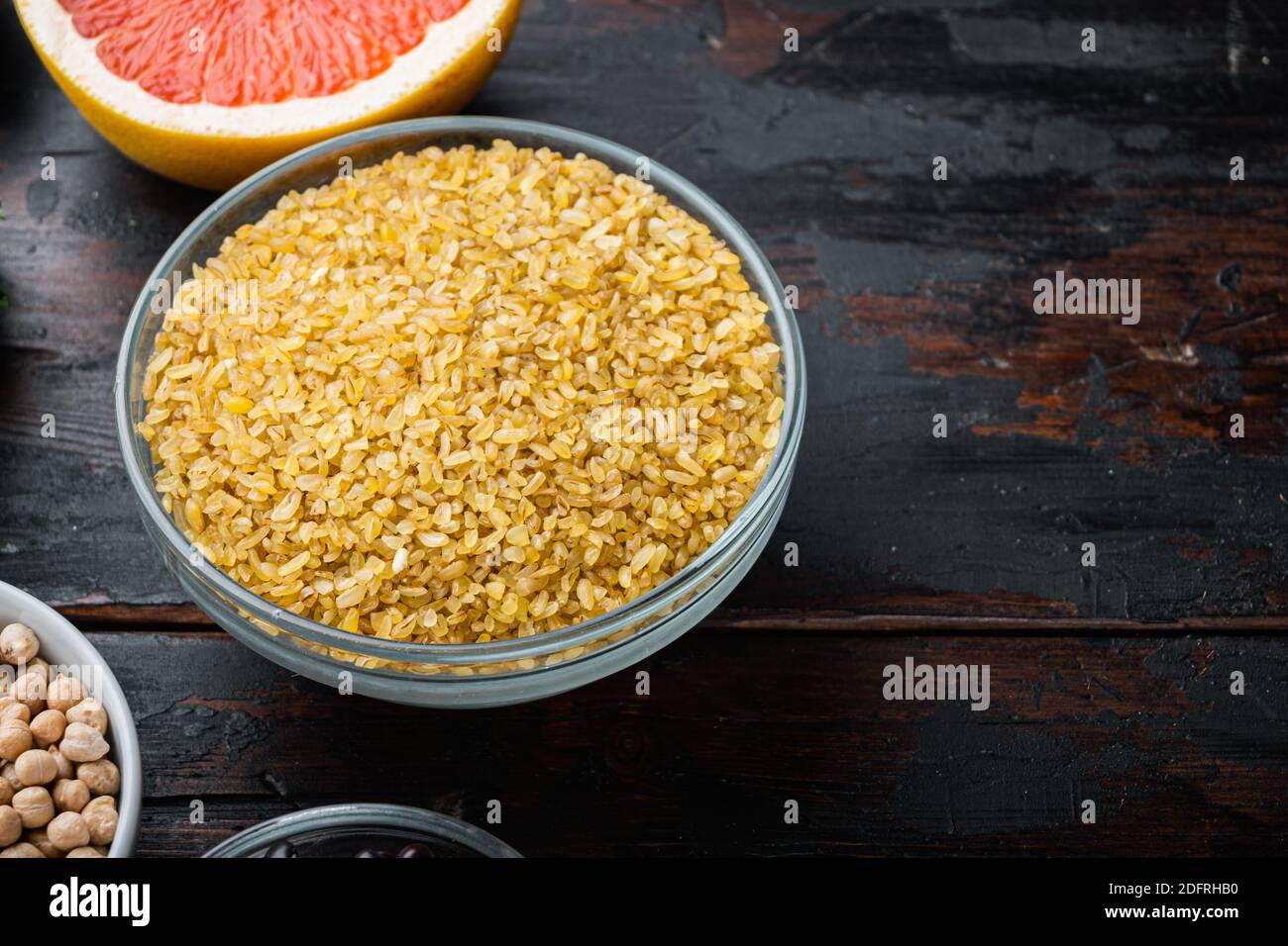 Bulgur grain in bowl on dark wooden background, with space for text ...