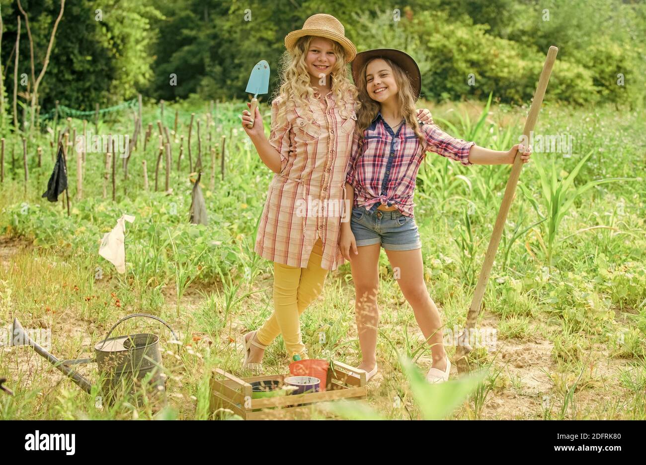 Girls in hats planting plants. Rustic children nature background. Eco ...