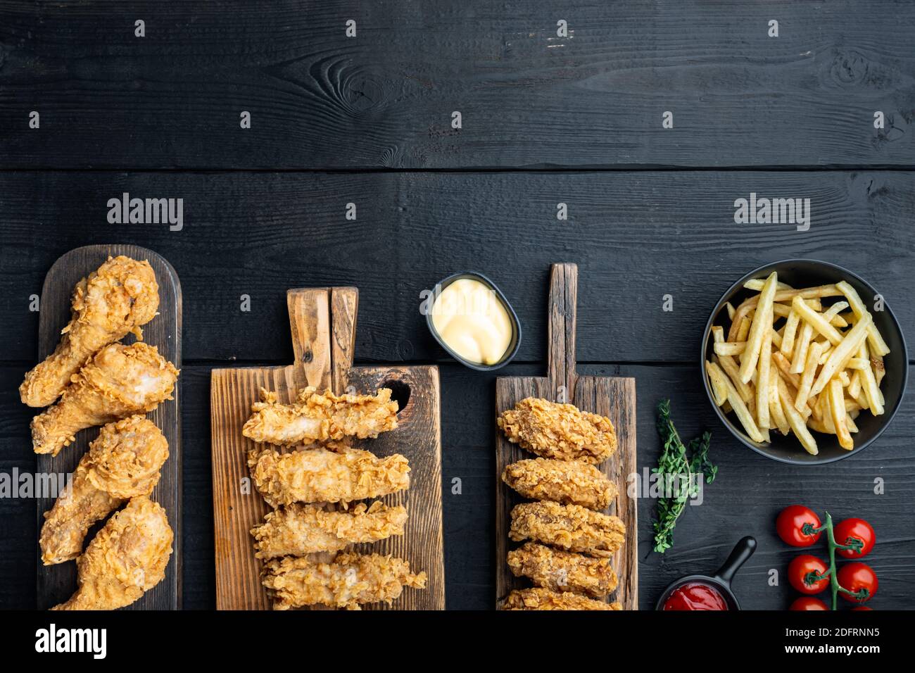Crispy fried chicken parts on black wooden table, top view, with copy ...