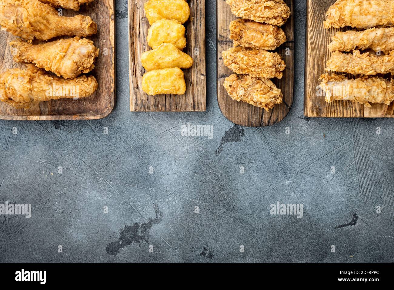 Homemade crispy fried chicken parts on grey background, top view, with ...
