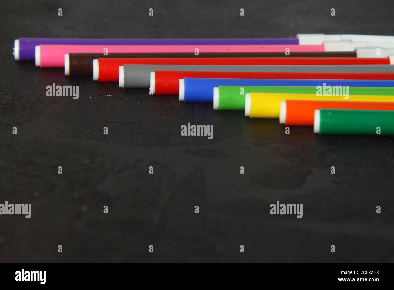 Multi-colored markers for drawing. Markers on a black isolated ...