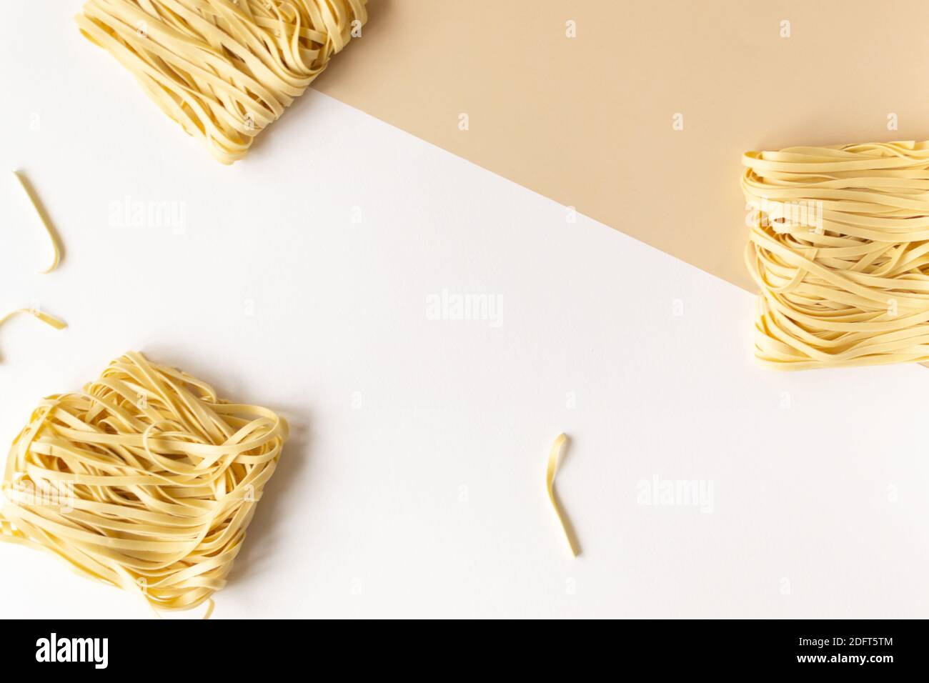 Natural dry homemade noodles on brown and white background. Horizontal ...