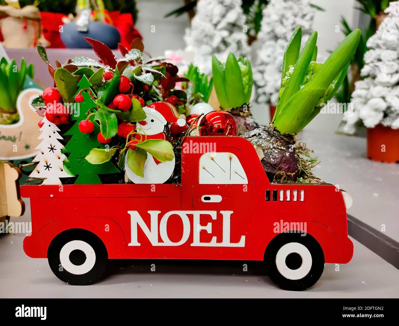 Noel red car with floral Christmas composition Stock Photo - Alamy