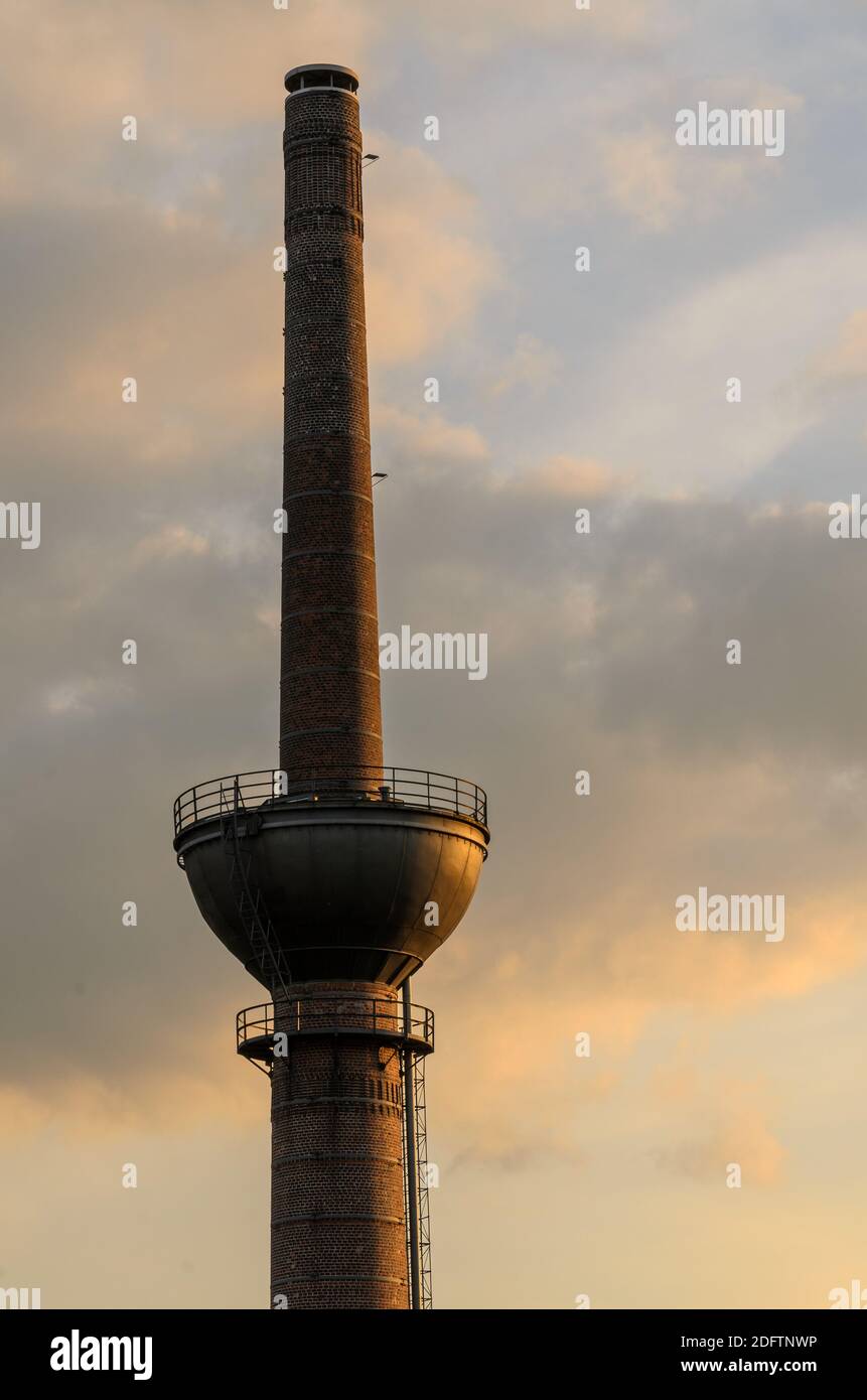 Old brick factory chimney in golden sunlight at evening Stock Photo - Alamy