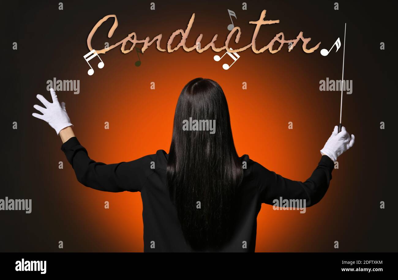 Young female conductor on dark color background, back view Stock Photo ...