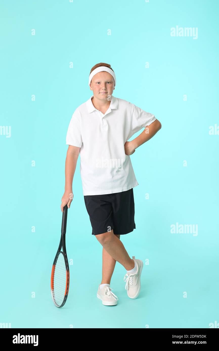 Sporty teenage boy with tennis racket on color background Stock Photo ...