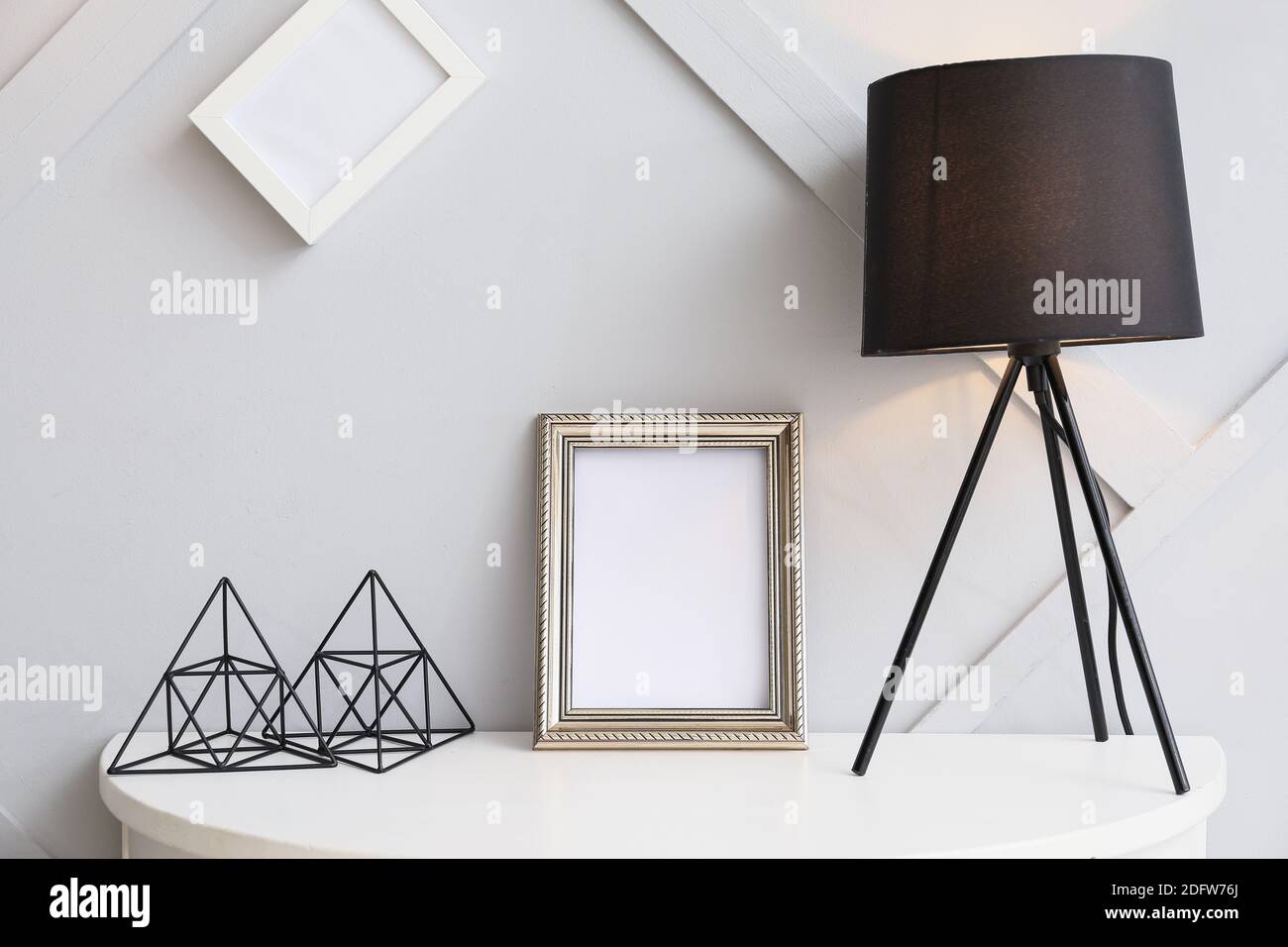 Blank photo frame and lamp on table in room Stock Photo - Alamy