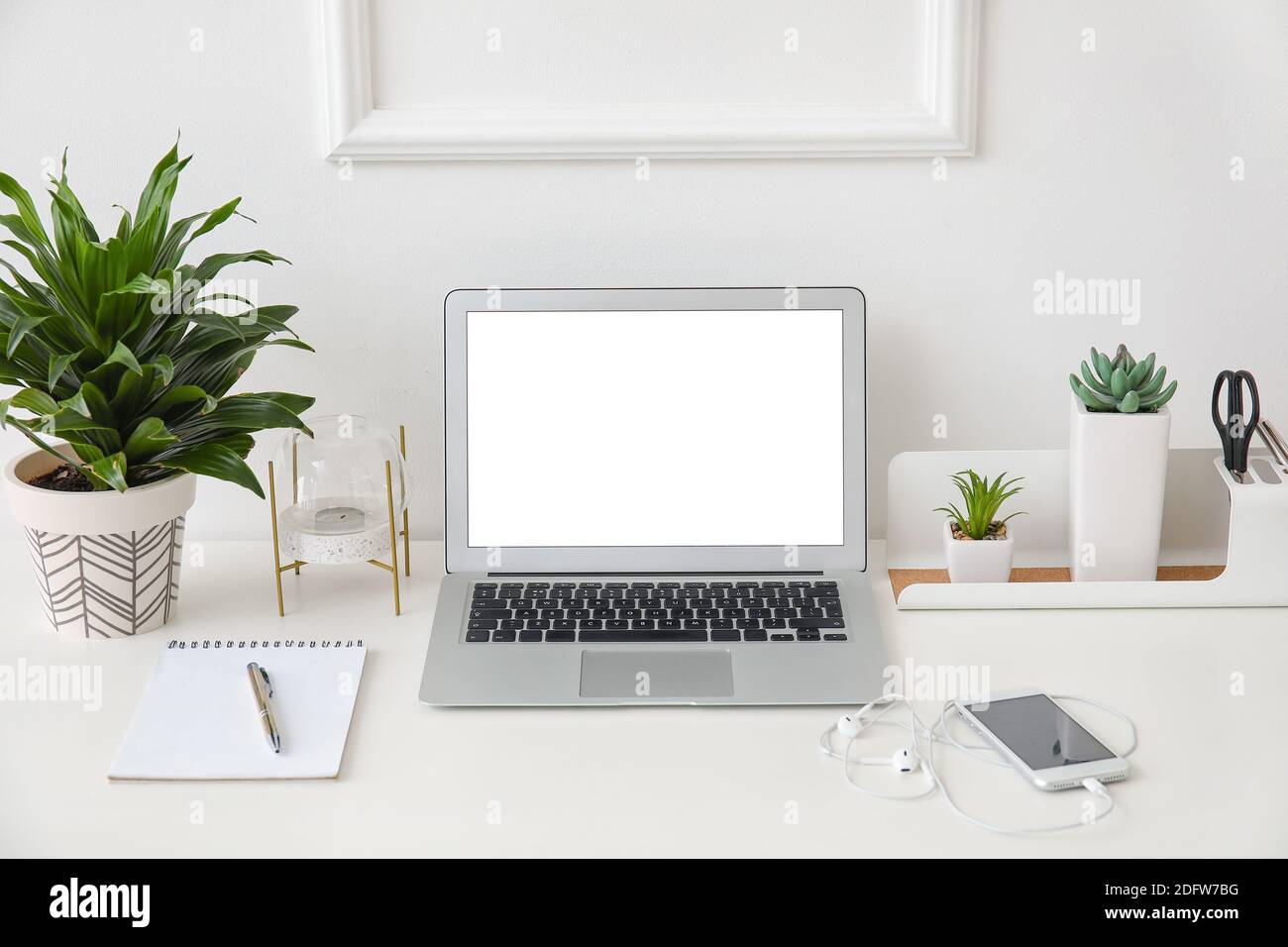 Stylish workplace with laptop near white wall Stock Photo - Alamy