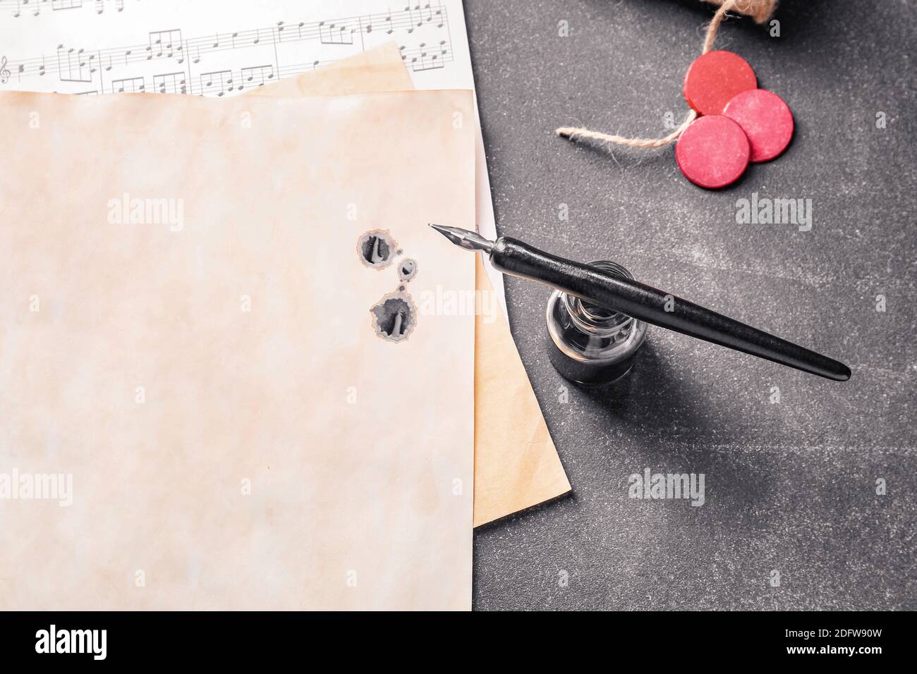 Nib pen, inkwell and musical note sheets on black table Stock Photo - Alamy