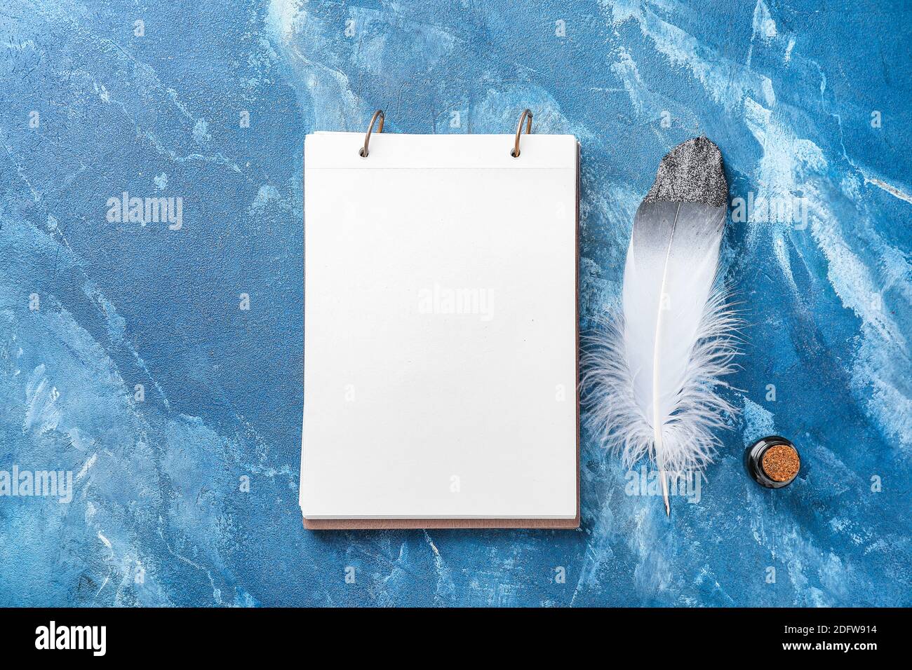 Notebook, feather pen and inkwell on table Stock Photo - Alamy