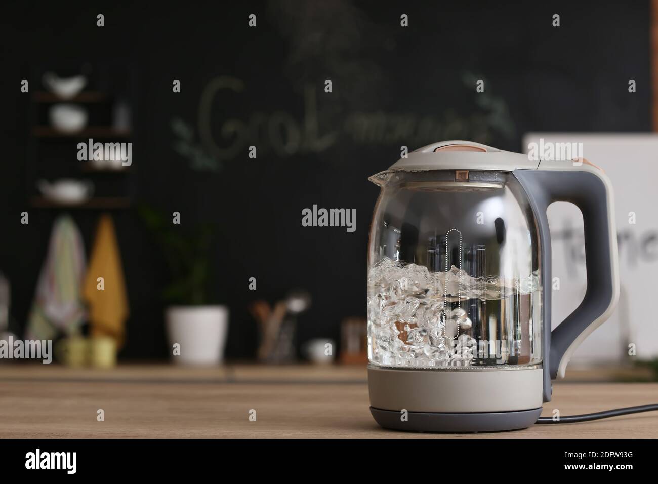 Electric kettle with boiling water on kitchen table Stock Photo - Alamy