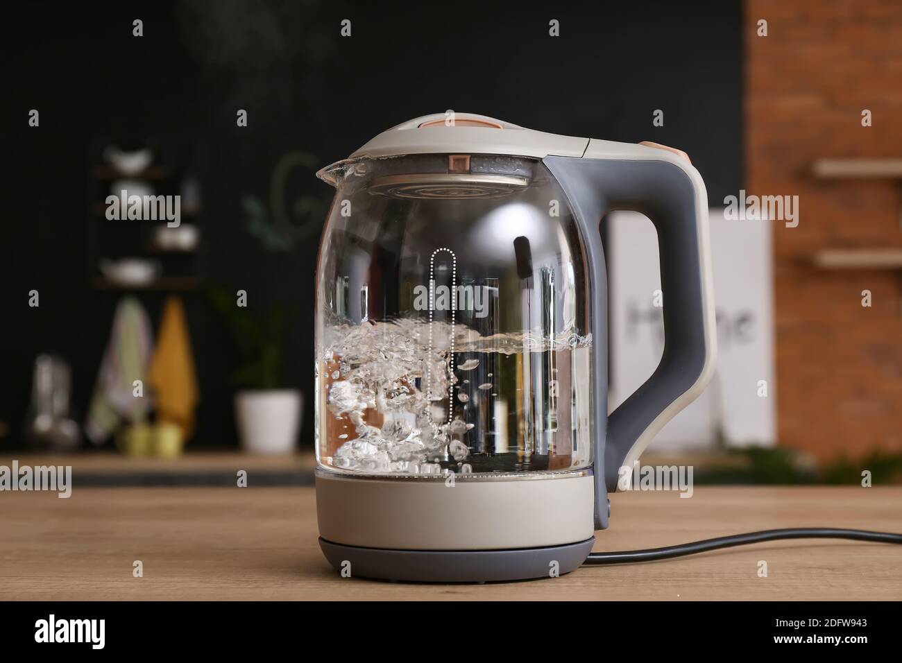 Electric kettle with boiling water on kitchen table Stock Photo - Alamy