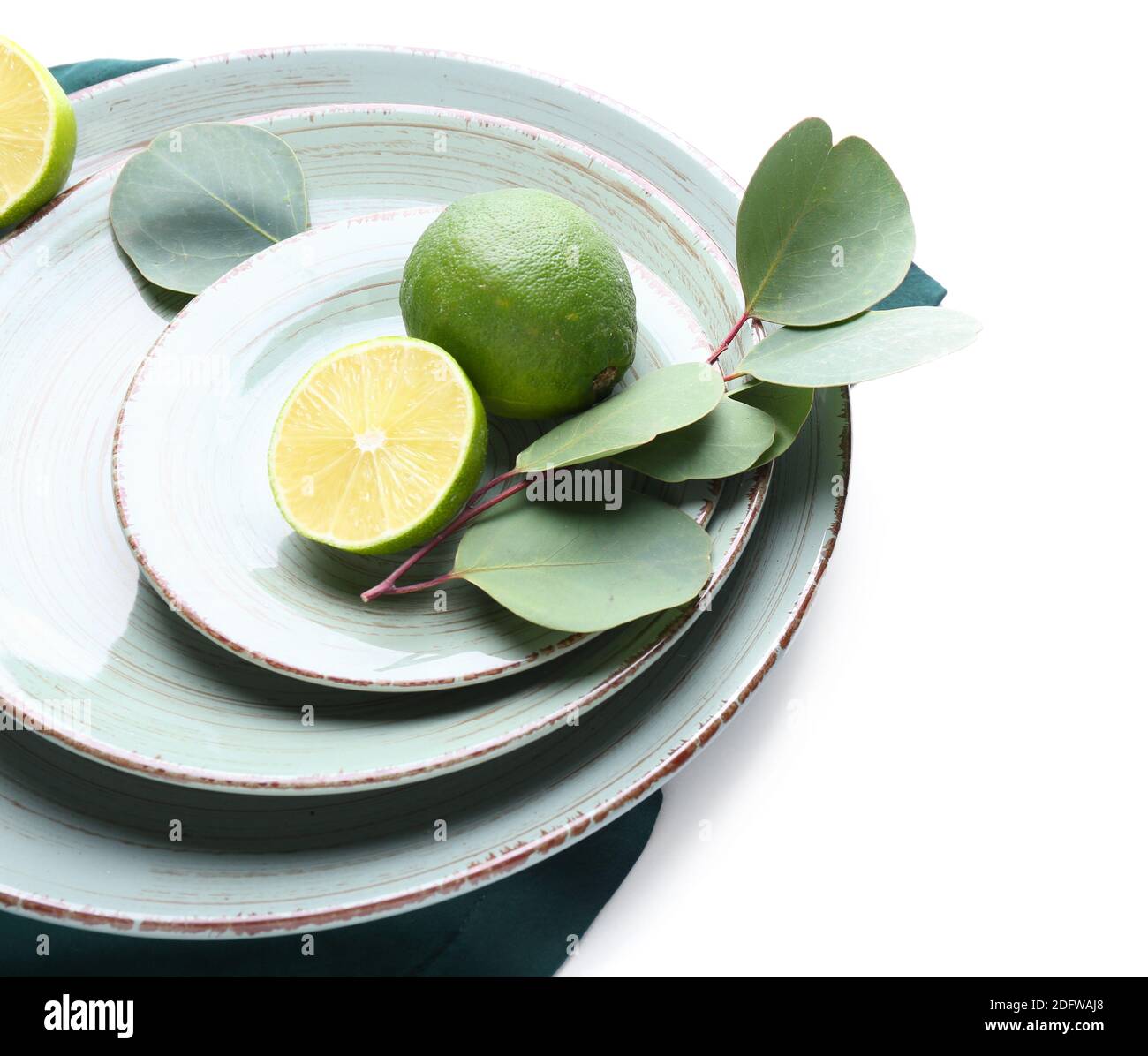 Beautiful table setting with lime and eucalyptus on white background ...