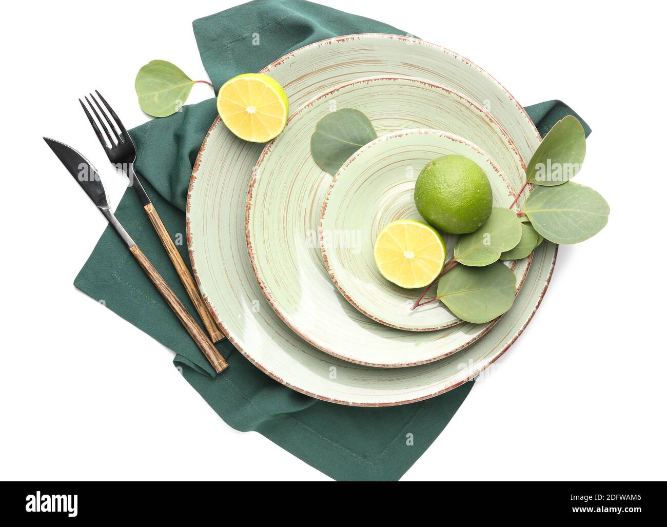 Beautiful table setting with lime and eucalyptus on white background ...