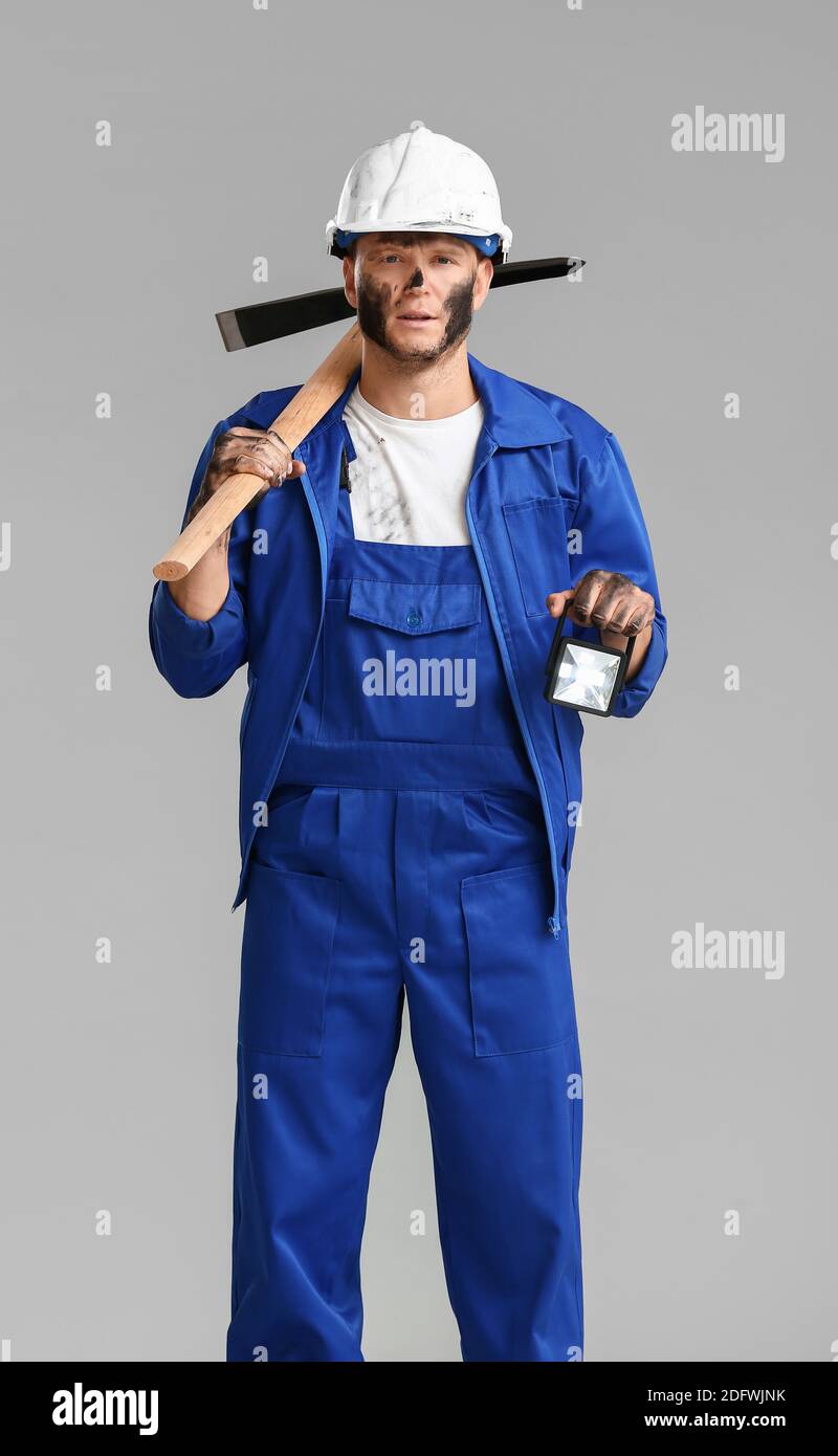Miner man with pick axe on grey background Stock Photo - Alamy