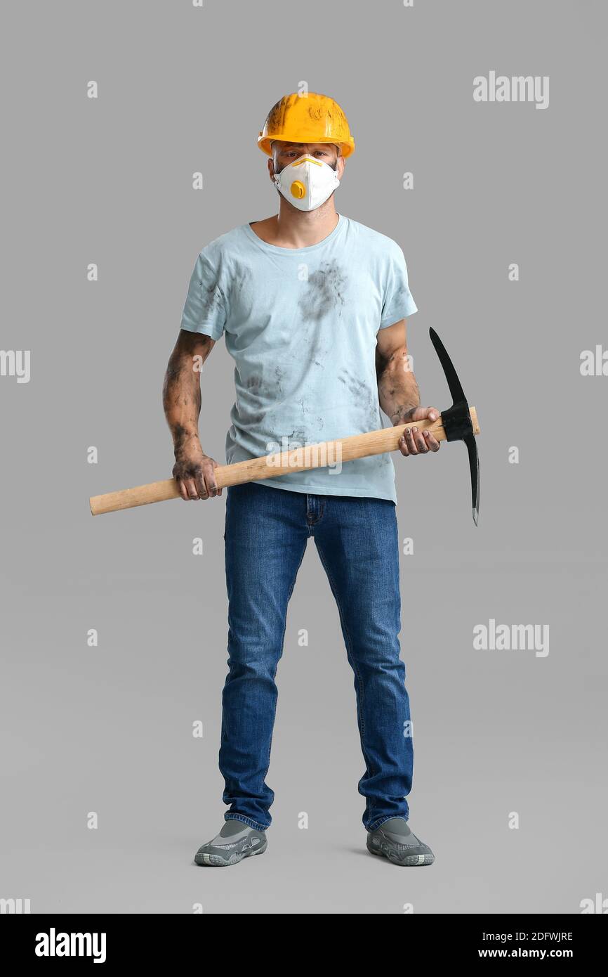 Miner man with pick axe on grey background Stock Photo - Alamy