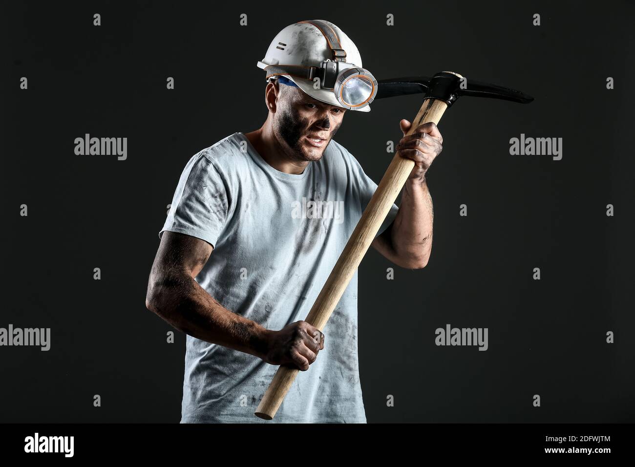 Miner man with pick axe on dark background Stock Photo - Alamy