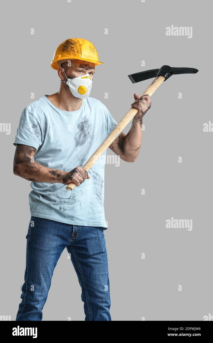 Miner man with pick axe on grey background Stock Photo - Alamy