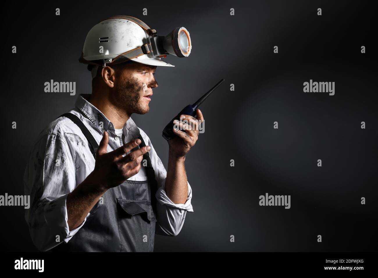Miner man with two-way radio on dark background Stock Photo - Alamy