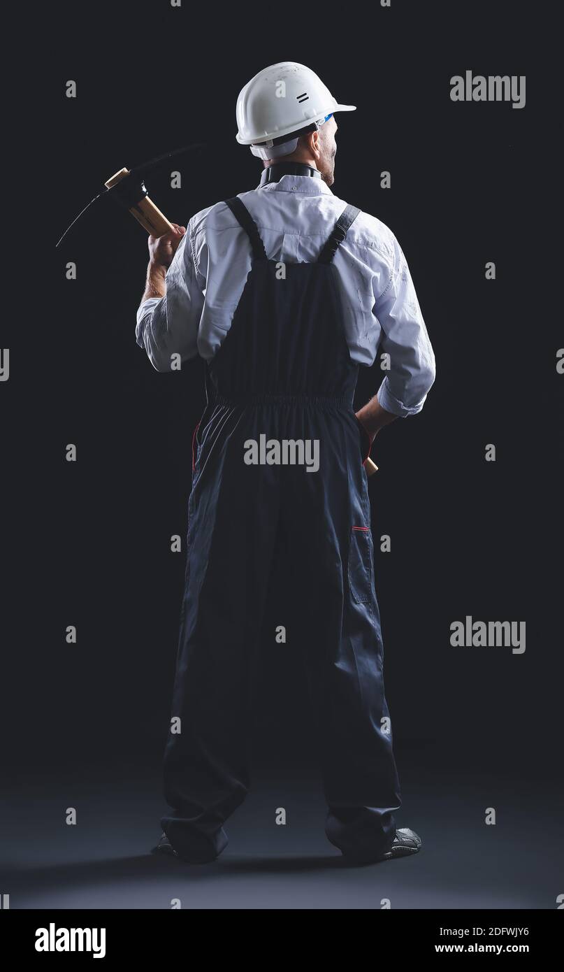 Miner man with pick axe on dark background Stock Photo - Alamy