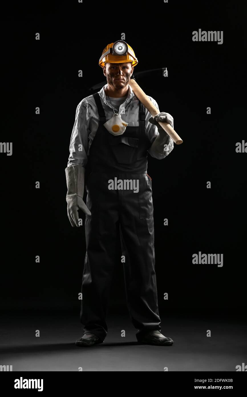 Miner man with pick axe on dark background Stock Photo - Alamy