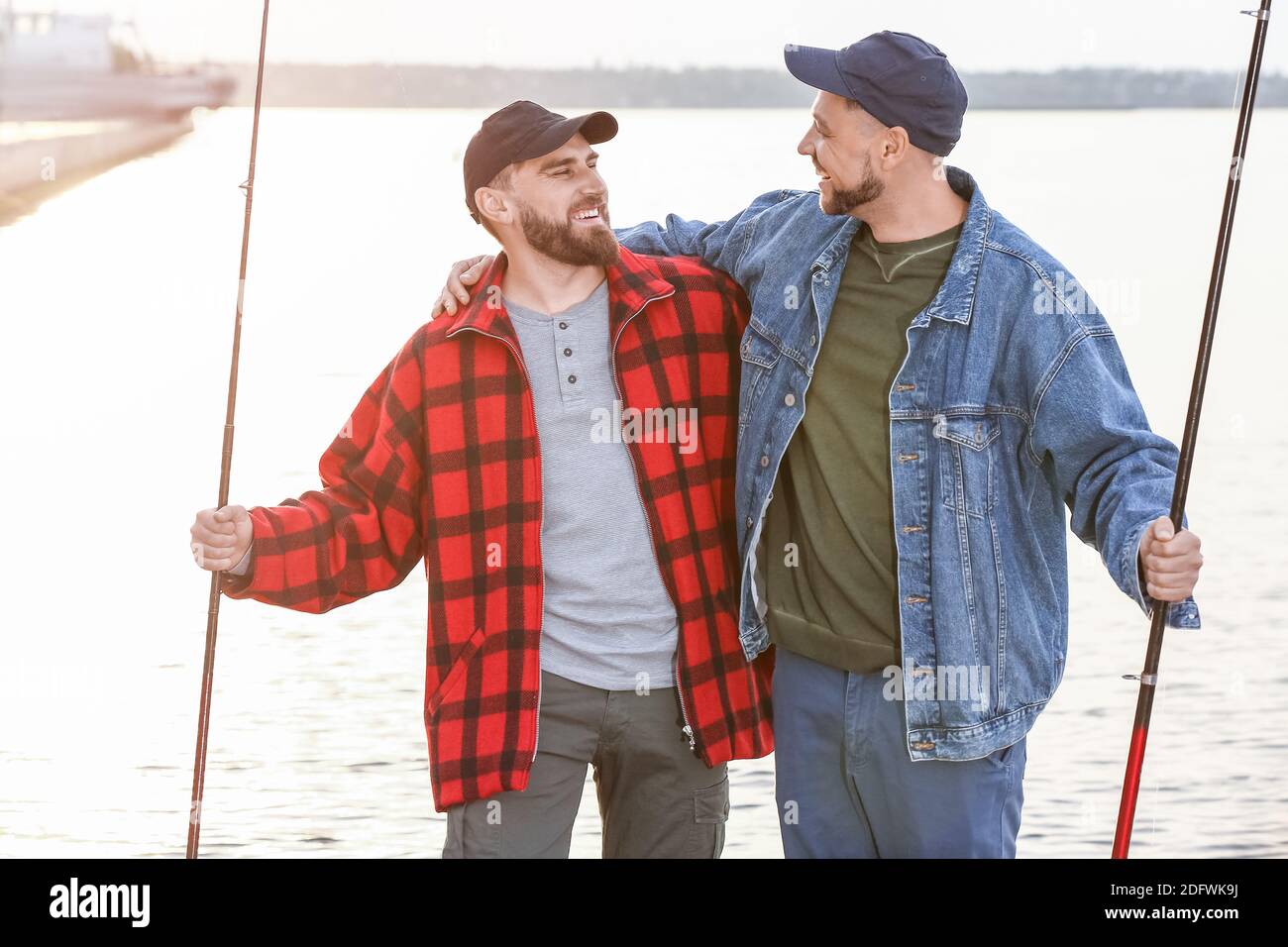 Happy young men fishing on river Stock Photo - Alamy