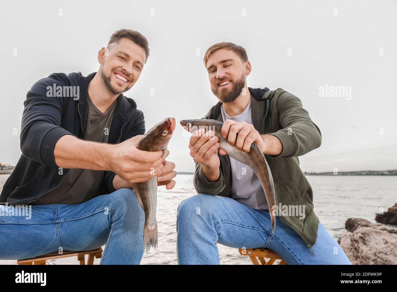 Young men fishing on river Stock Photo - Alamy