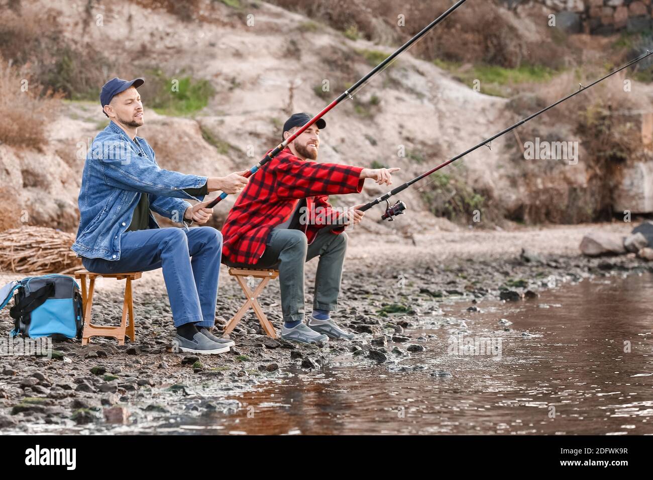 Young men fishing on river Stock Photo - Alamy