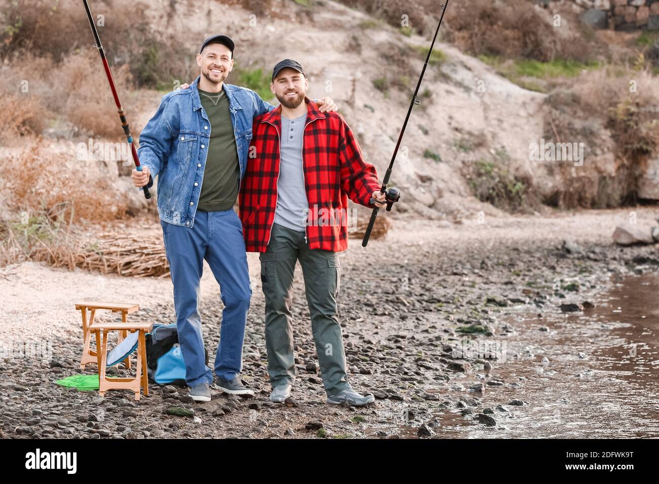 Happy young men fishing on river Stock Photo - Alamy