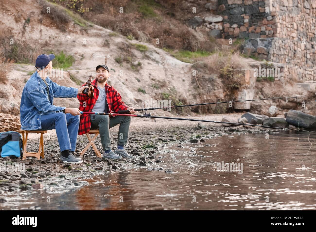 Young men fishing on river Stock Photo - Alamy