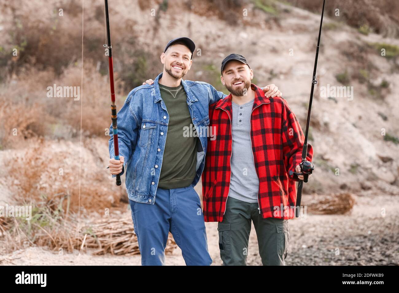 Happy young men fishing on river Stock Photo - Alamy