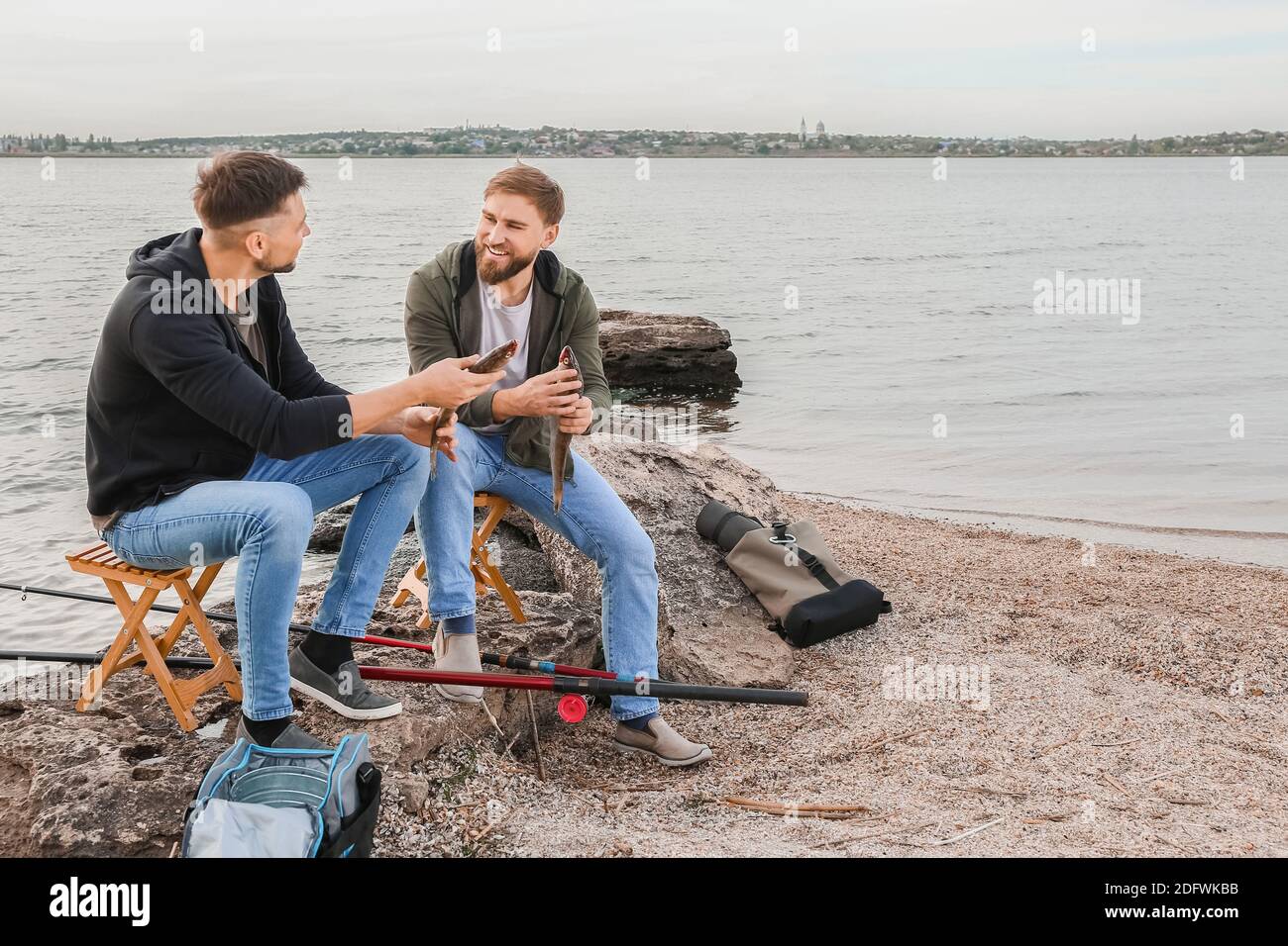 Young men fishing on river Stock Photo - Alamy