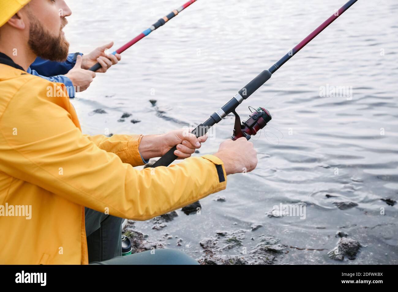 Young men fishing on river Stock Photo - Alamy