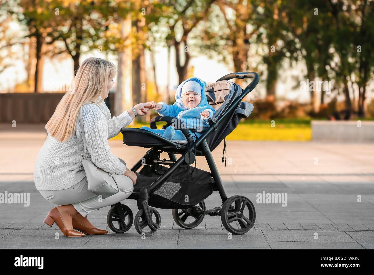 Woman and her cute baby in stroller outdoors Stock Photo - Alamy