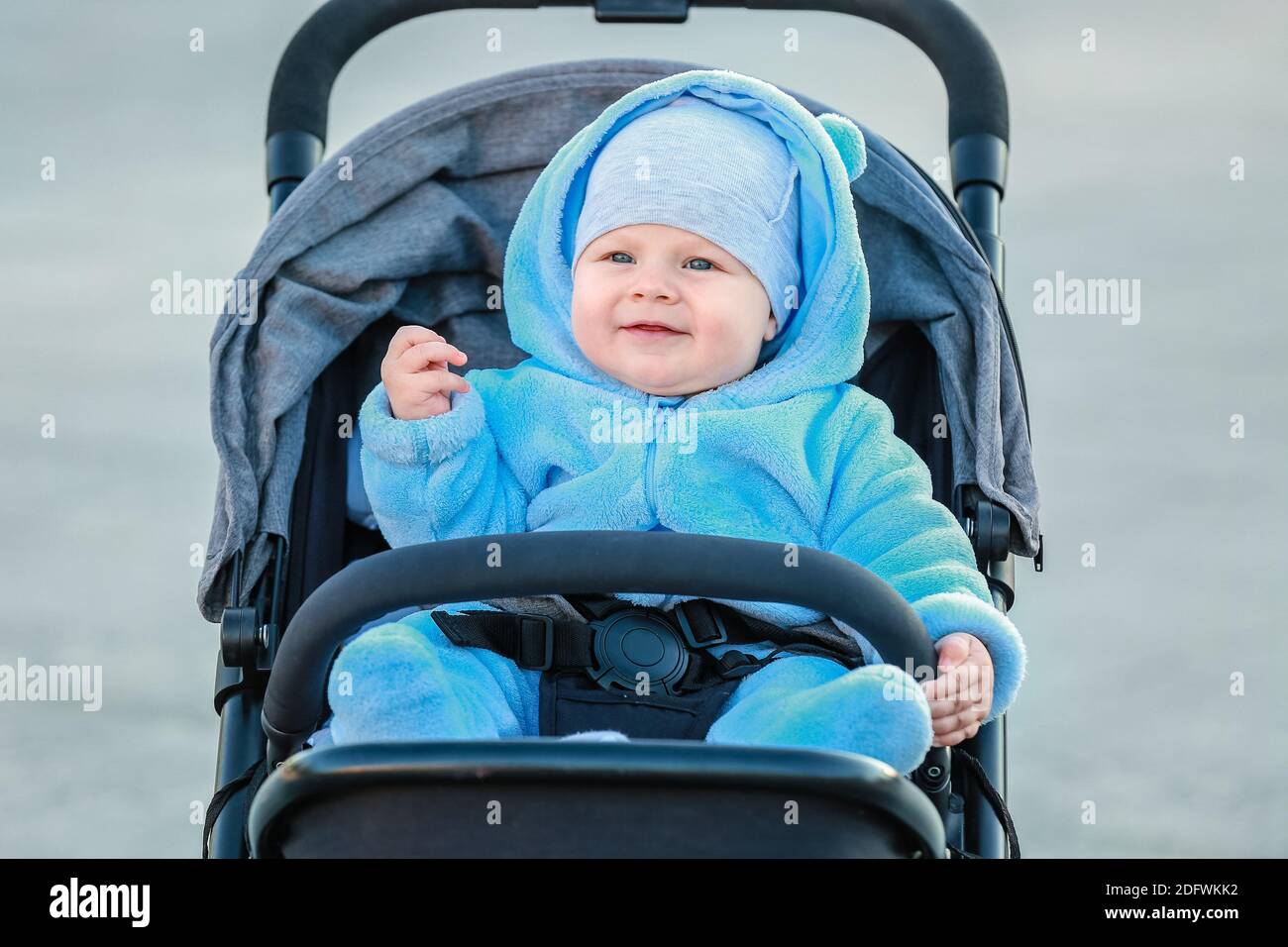 Cute funny baby in stroller outdoors Stock Photo - Alamy