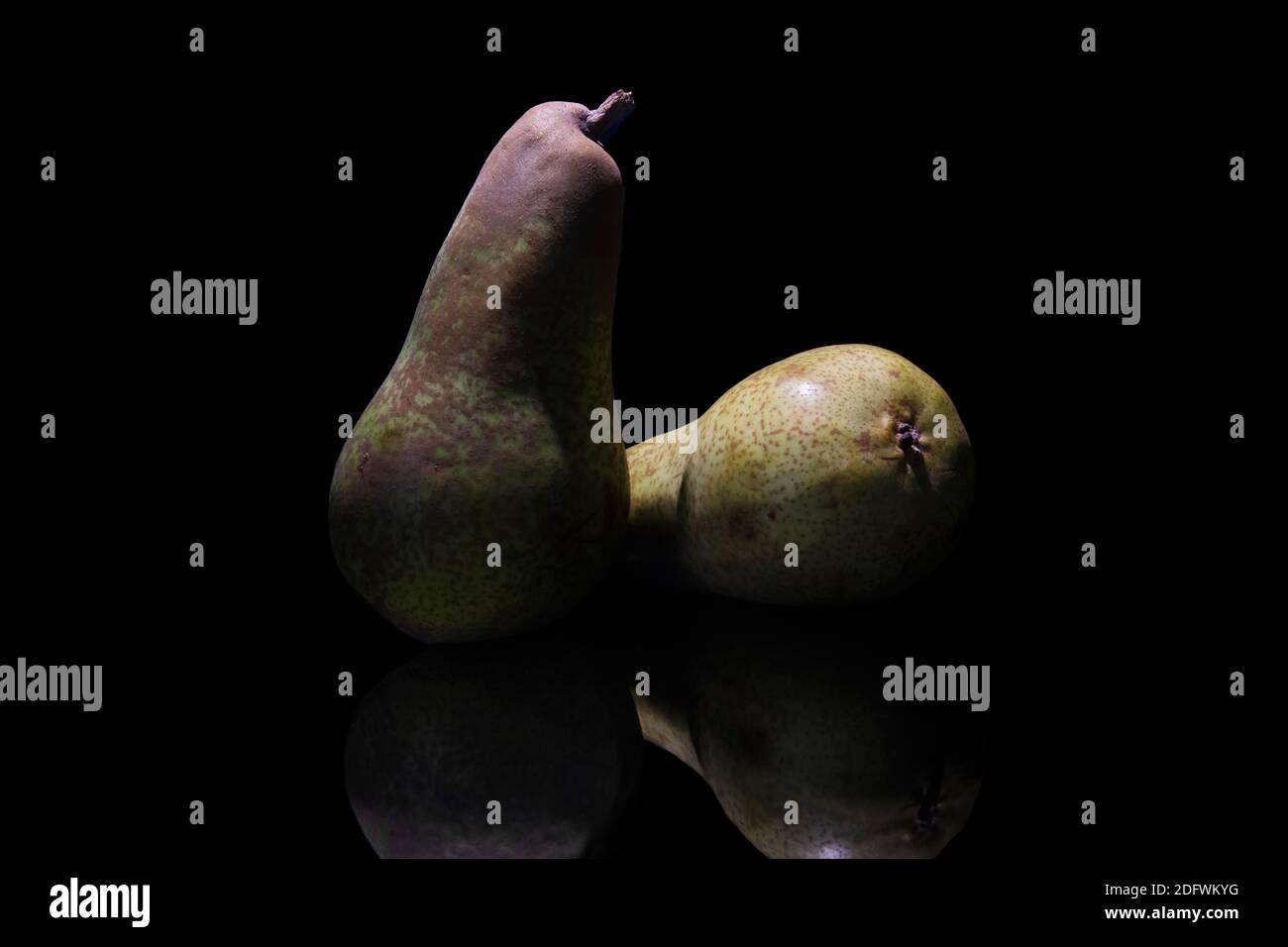 Two pear against a black background Stock Photo - Alamy