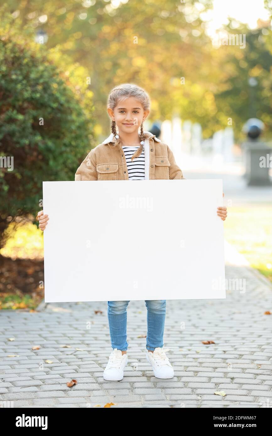 Cute little girl with blank poster outdoors Stock Photo - Alamy