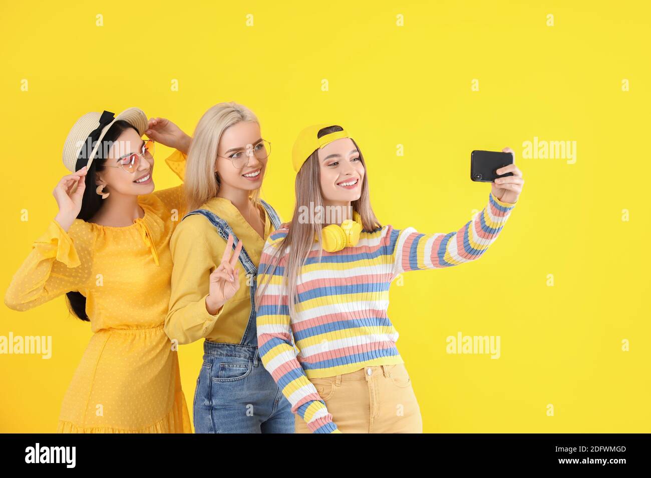 Beautiful young women taking selfie on color background Stock Photo - Alamy