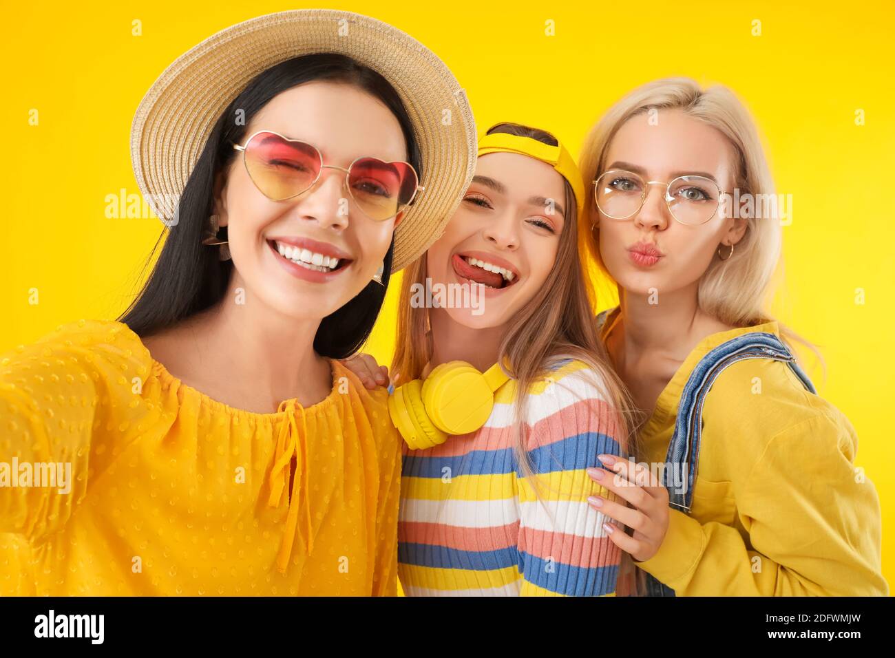 Beautiful young women taking selfie on color background Stock Photo - Alamy