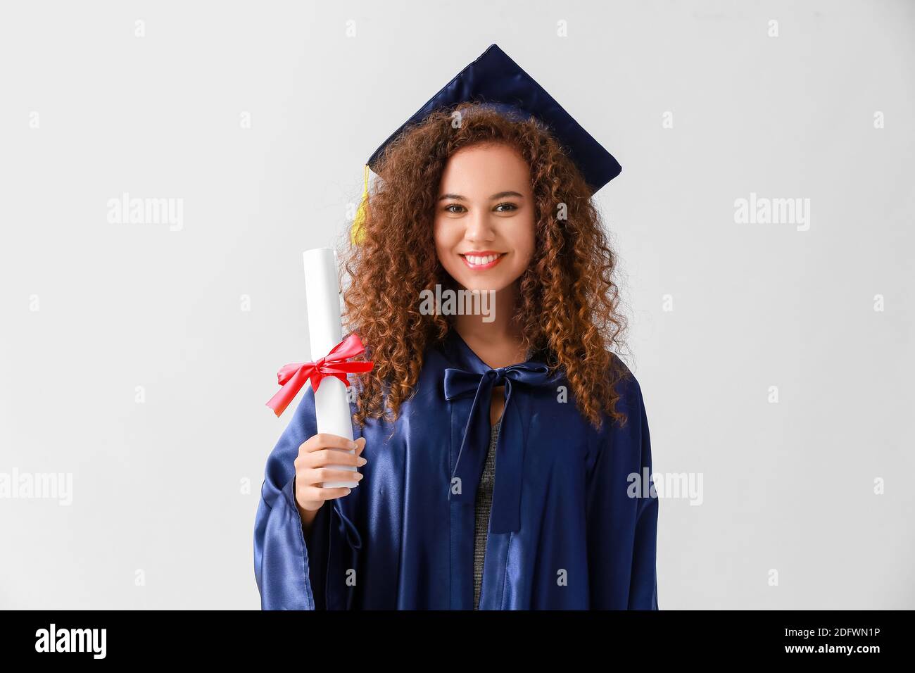 Female graduating student with diploma on light background Stock Photo ...