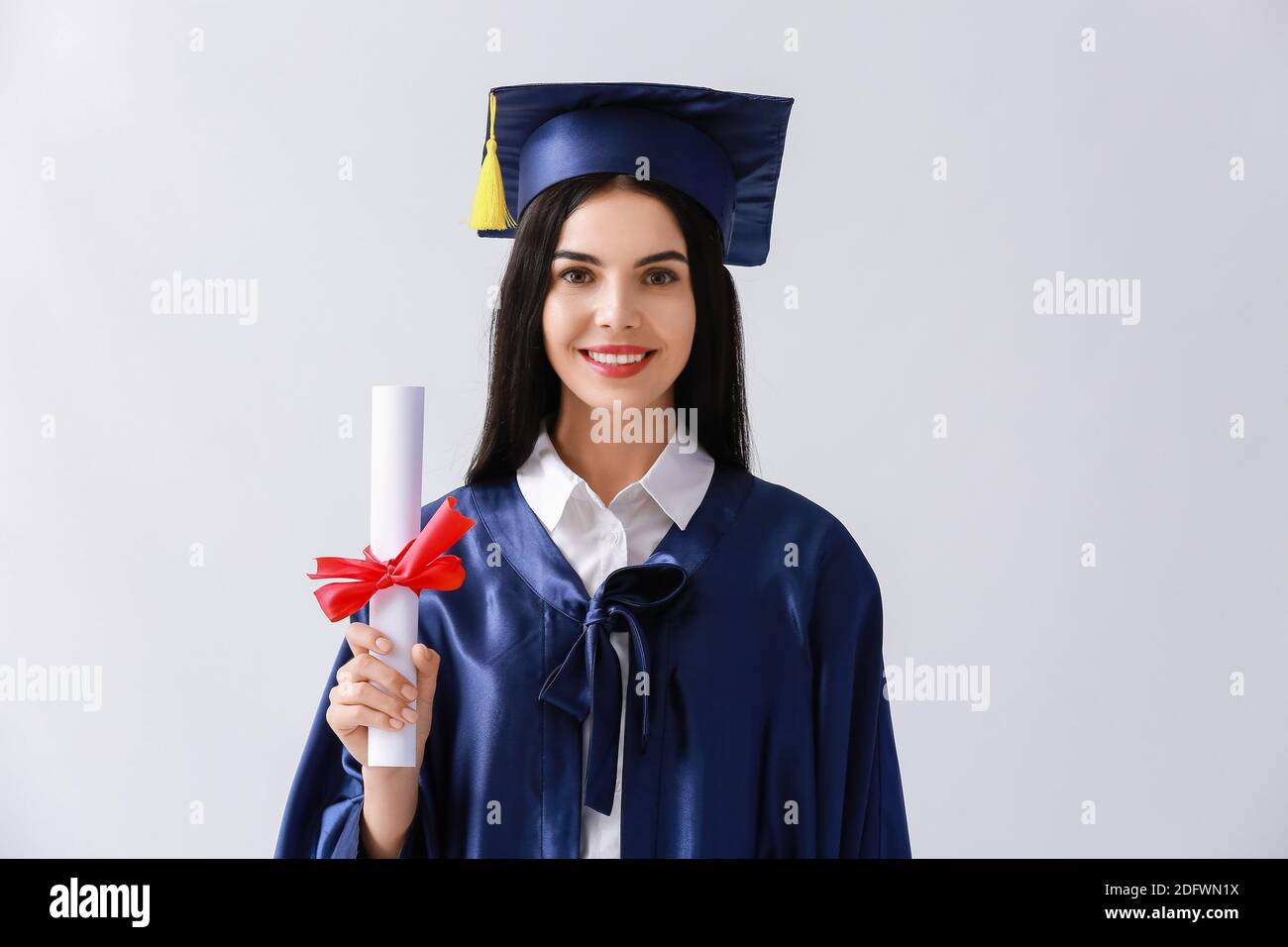 Female graduating student with diploma on light background Stock Photo ...