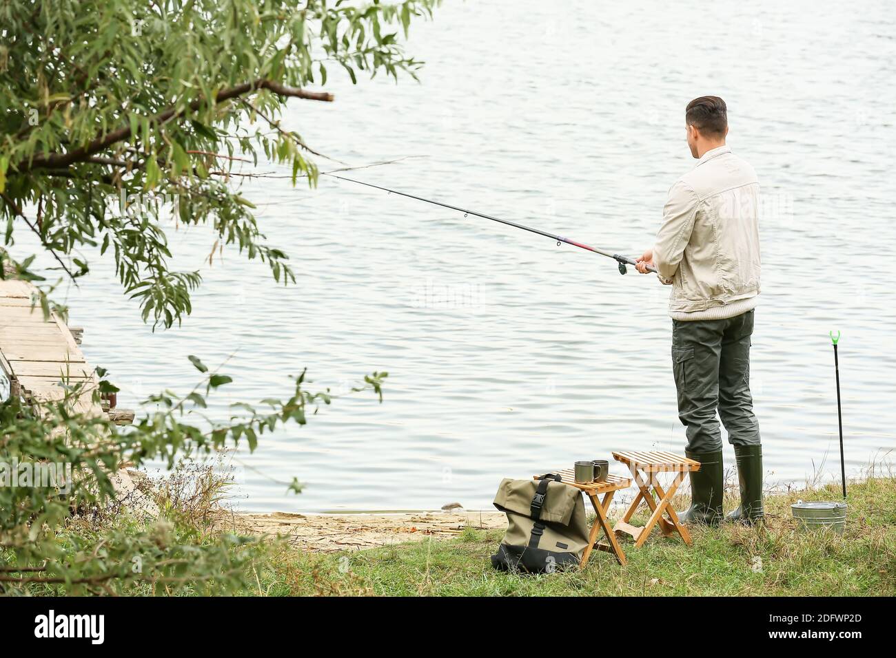 Young man fishing on river Stock Photo - Alamy