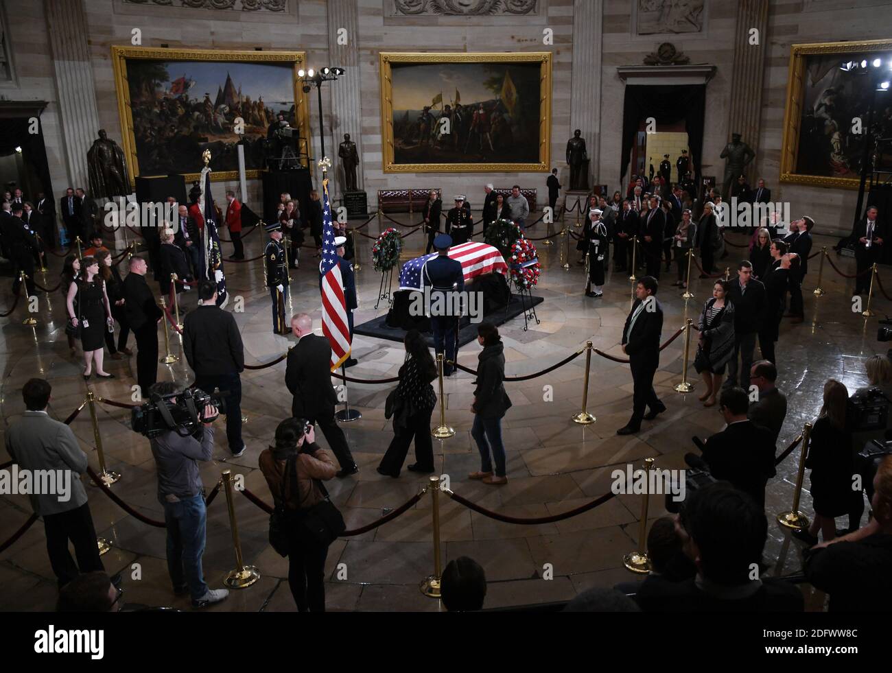 Visitors pay their respects in front of the flag-draped casket of ...