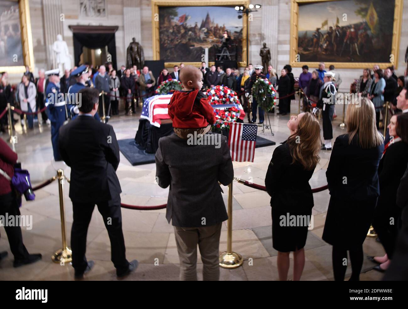 Visitors pay their respects in front of the flag-draped casket of ...
