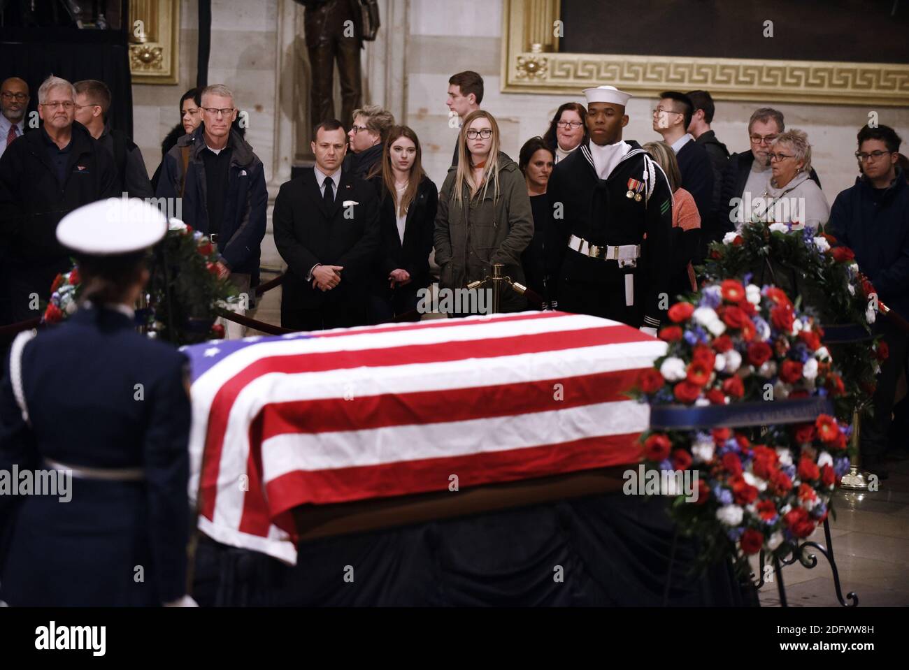 Visitors pay their respects in front of the flag-draped casket of ...