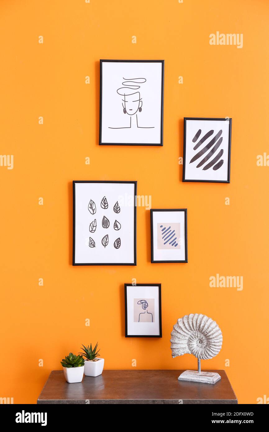 Table near wall with beautiful pictures Stock Photo - Alamy