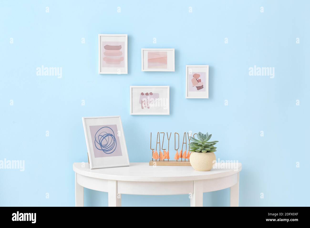 Table near wall with beautiful pictures Stock Photo - Alamy