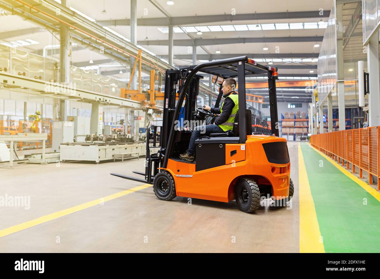 Storehouse employee in uniform working on forklift in modern automatic ...
